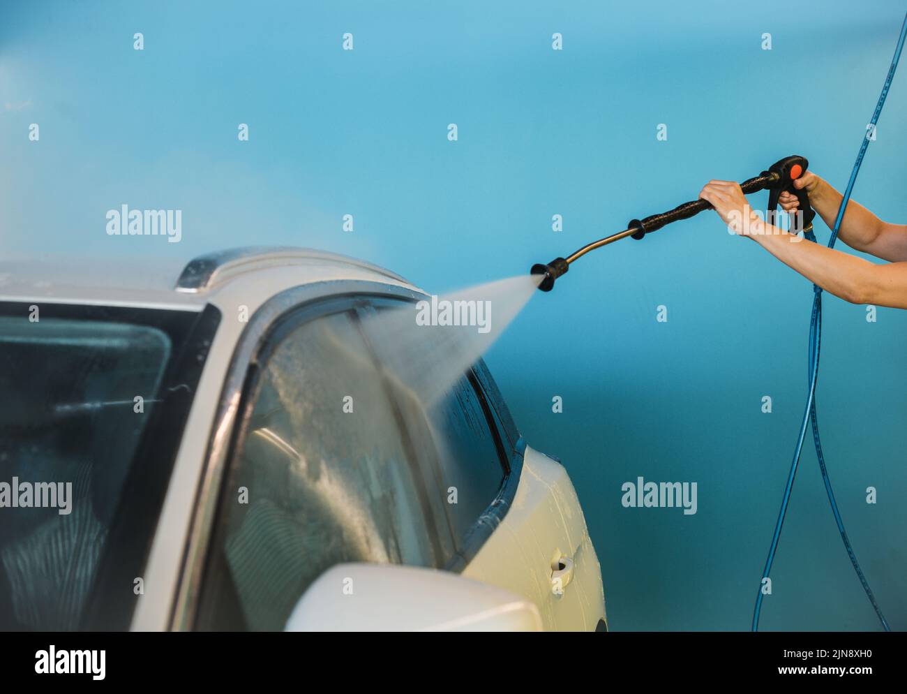 Crop woman washing windows of car Stock Photo - Alamy