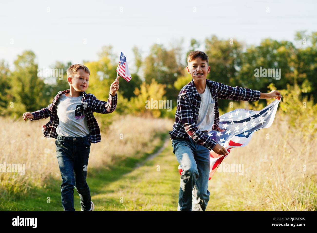 Two brothers running with USA flag. America holiday. Proud to be ...