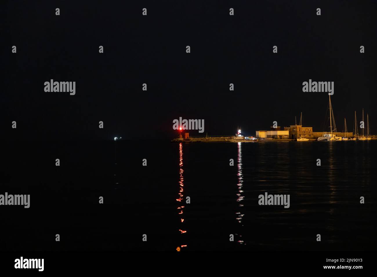 A scenic view of a lighthouse reflecting in Trieste's gulf, Italy at ...