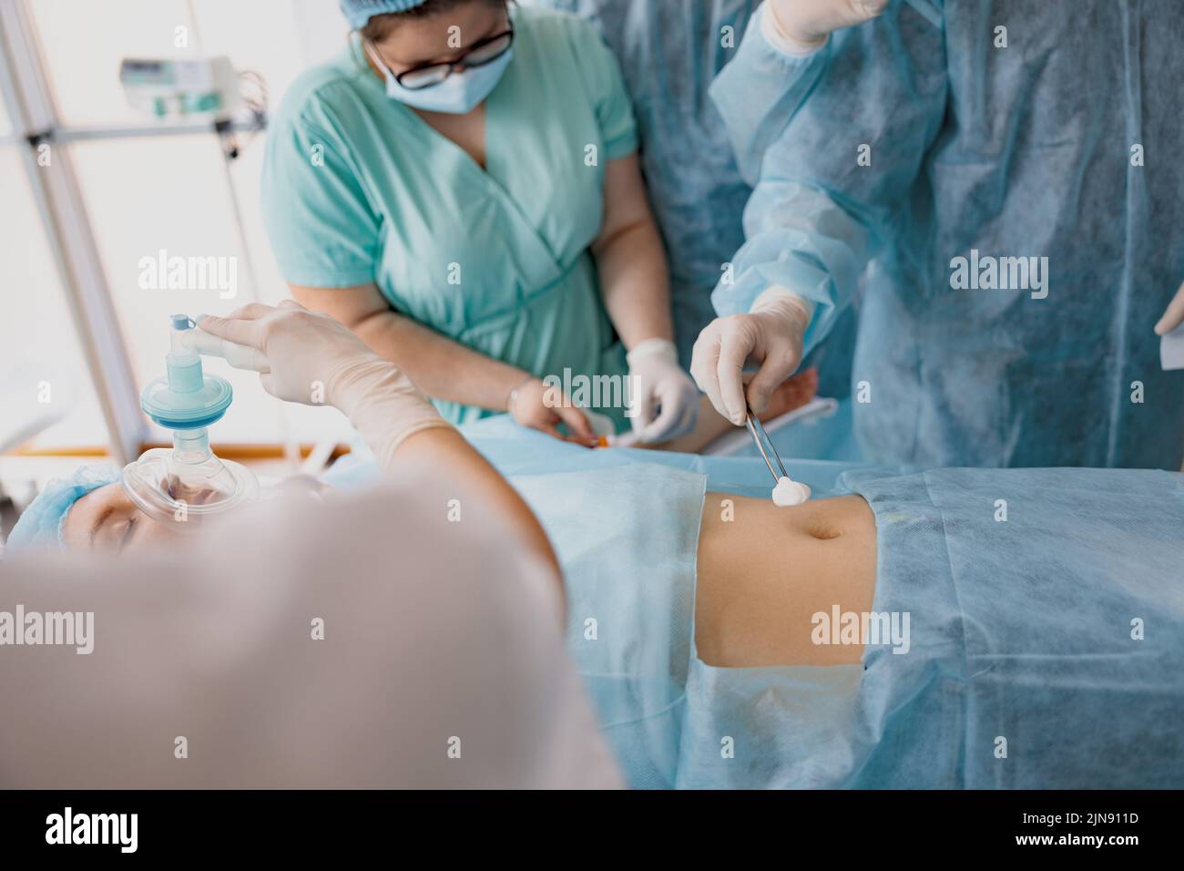 Nurse and doctor prepare patient skin for surgery using antiseptic ...