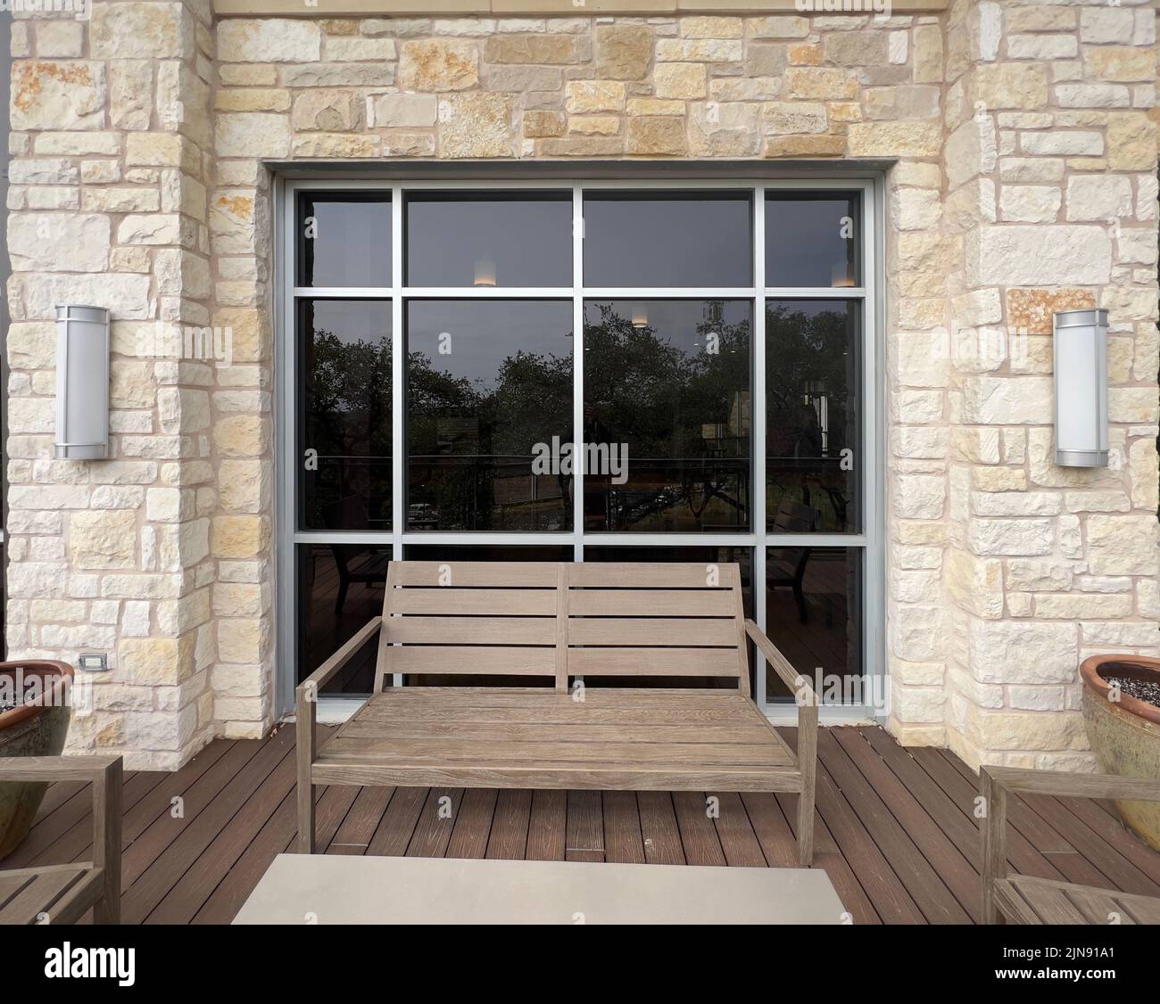 The beautiful patio wooden furniture by the window in the beige stone ...