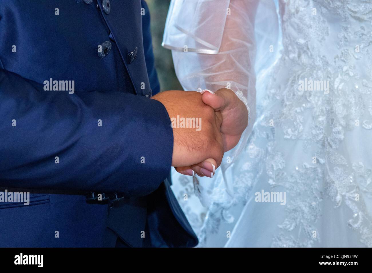Italy. September 2022. The groom and the bride shake their right hand ...
