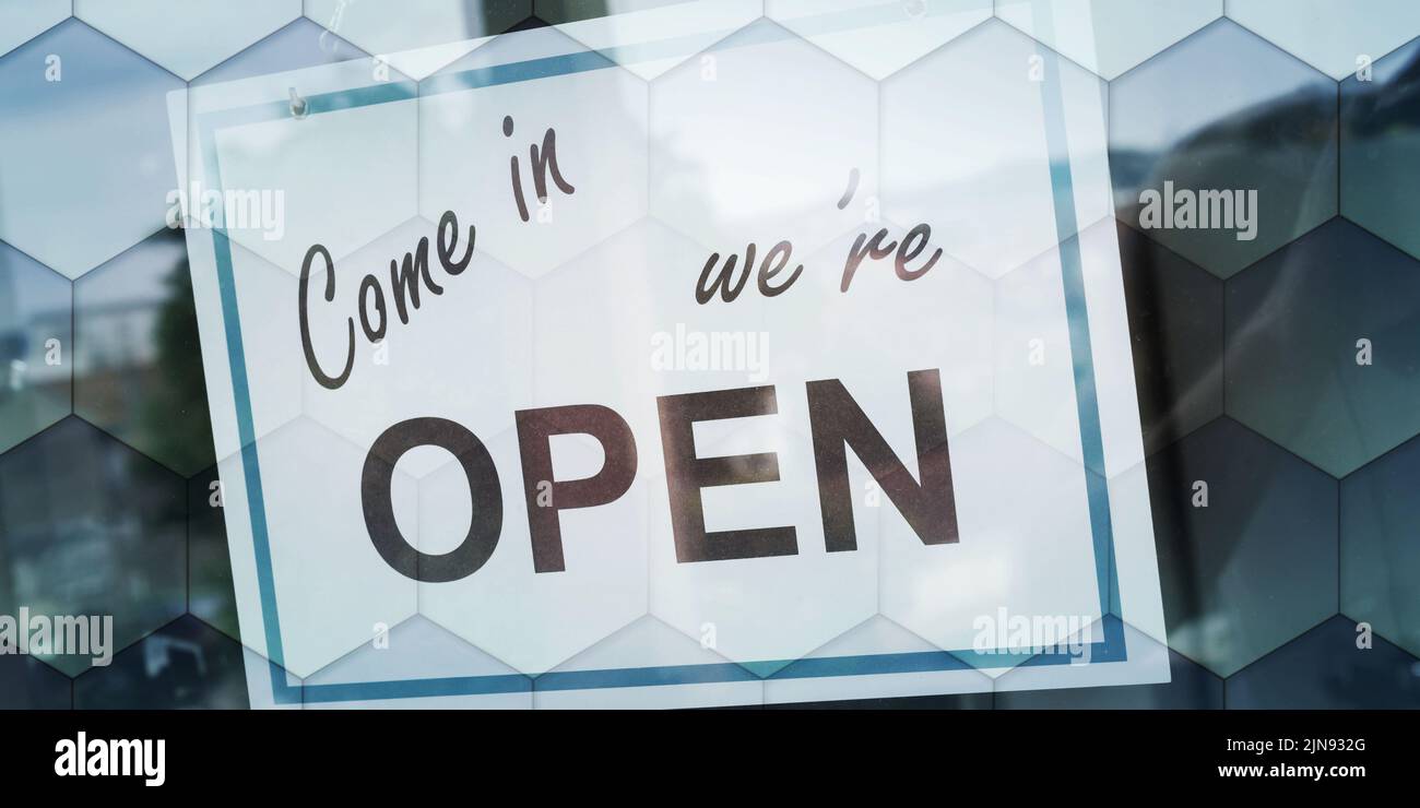 Come in we're open sign hanging behind a store window, geometric ...