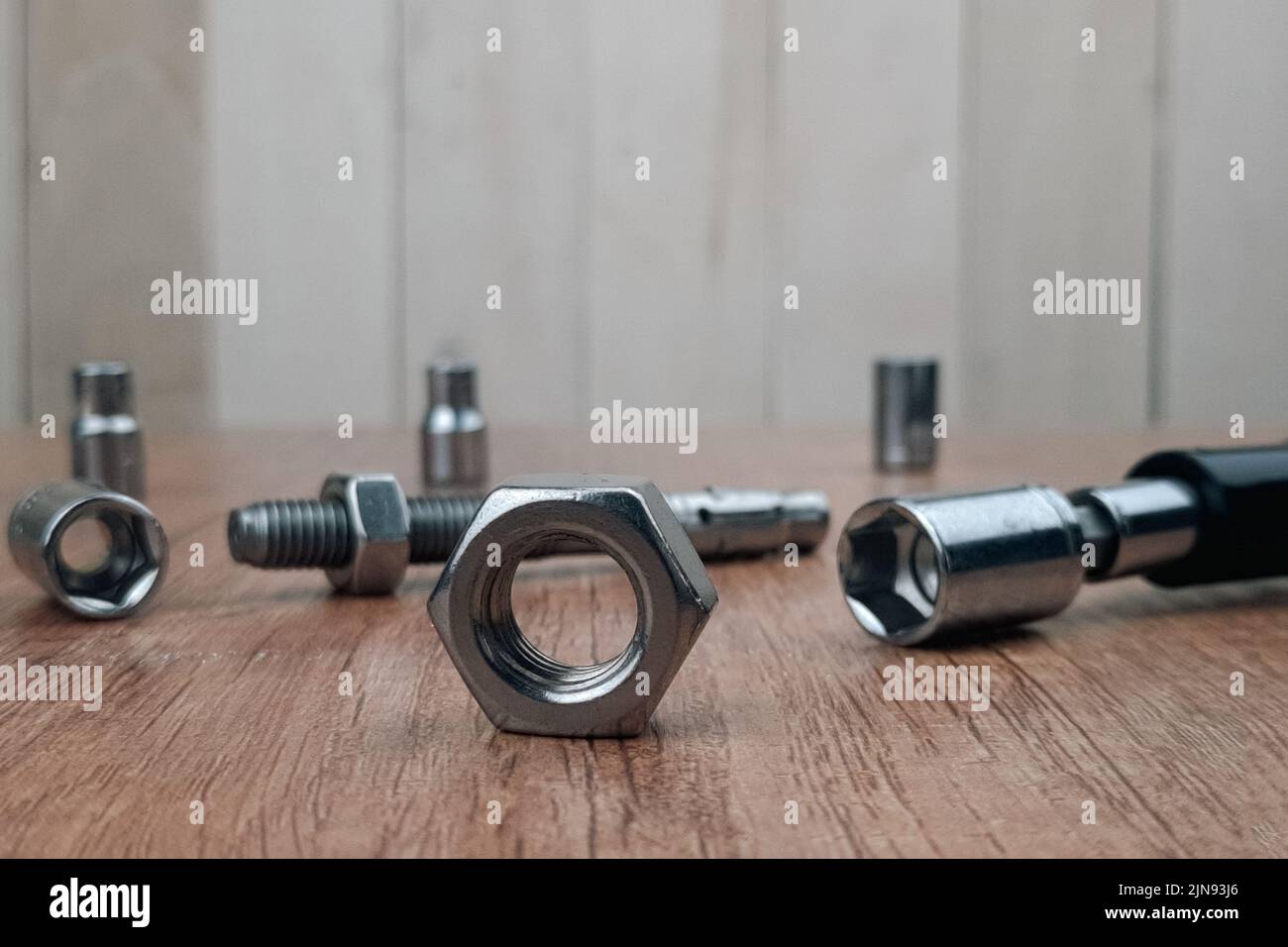 Metal nut with bolt closes on the table, close up. Background with copy ...