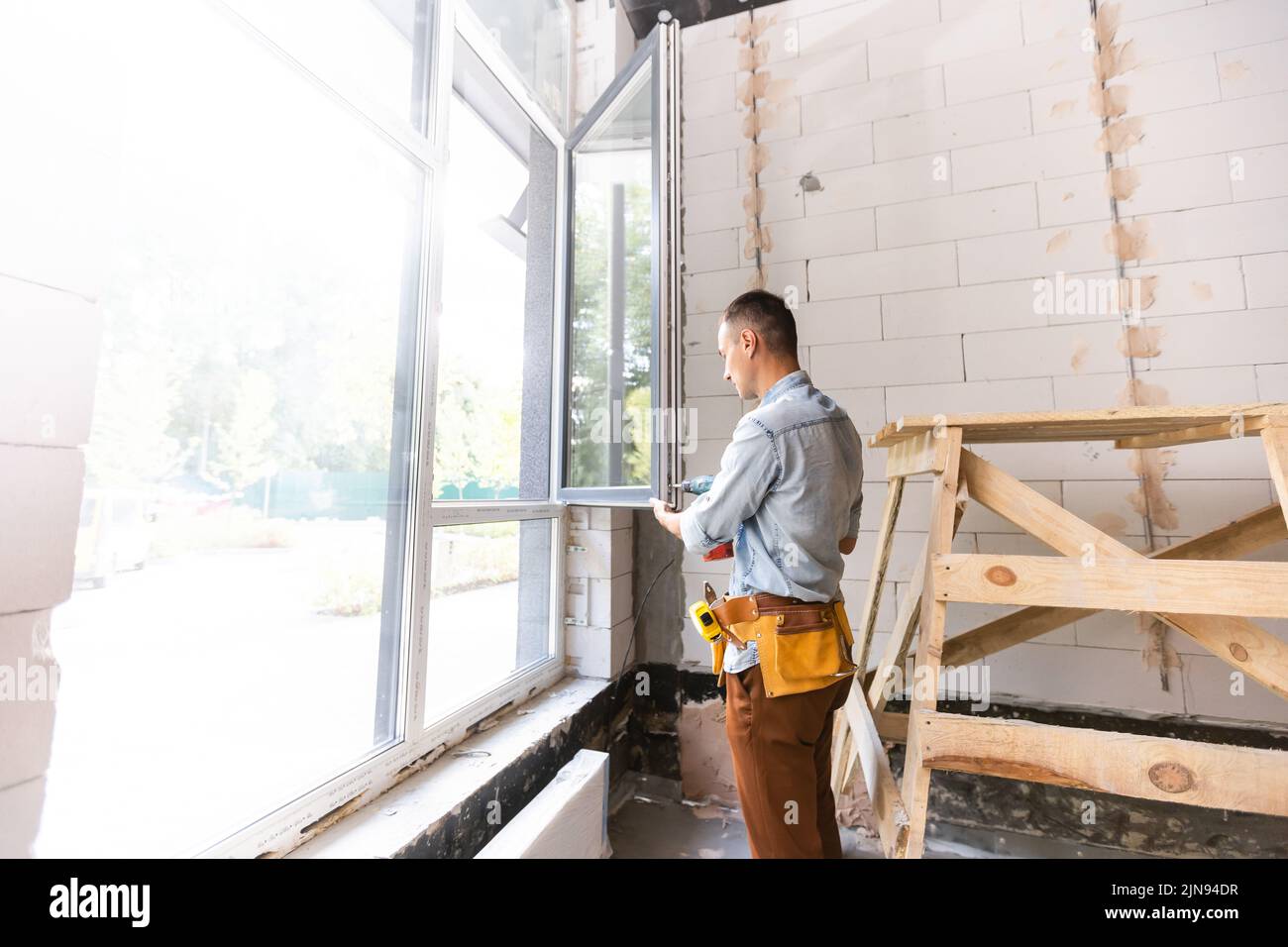 Construction worker installing window in house Stock Photo - Alamy