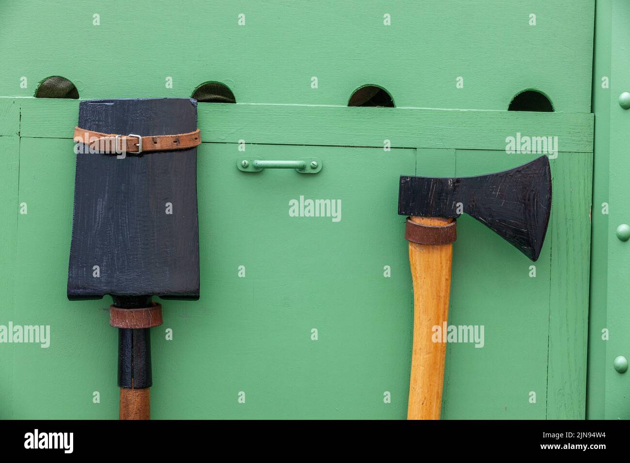 Spade and ax attached to the sides of an old military vehicle, during a ...