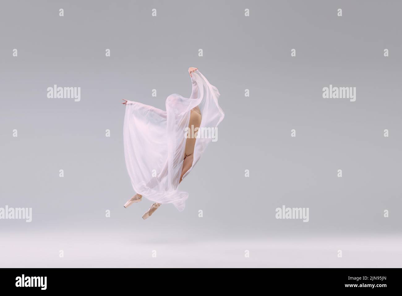 Portrait of young ballerina dancing, performing in beige cloth, covered ...