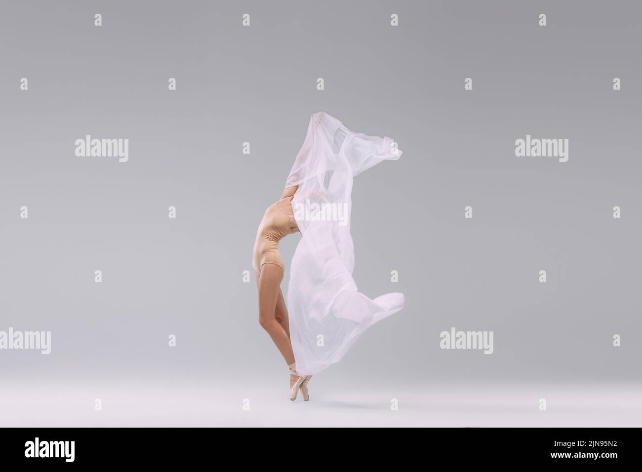 Portrait of young ballerina dancing, performing in beige bodysuit with ...