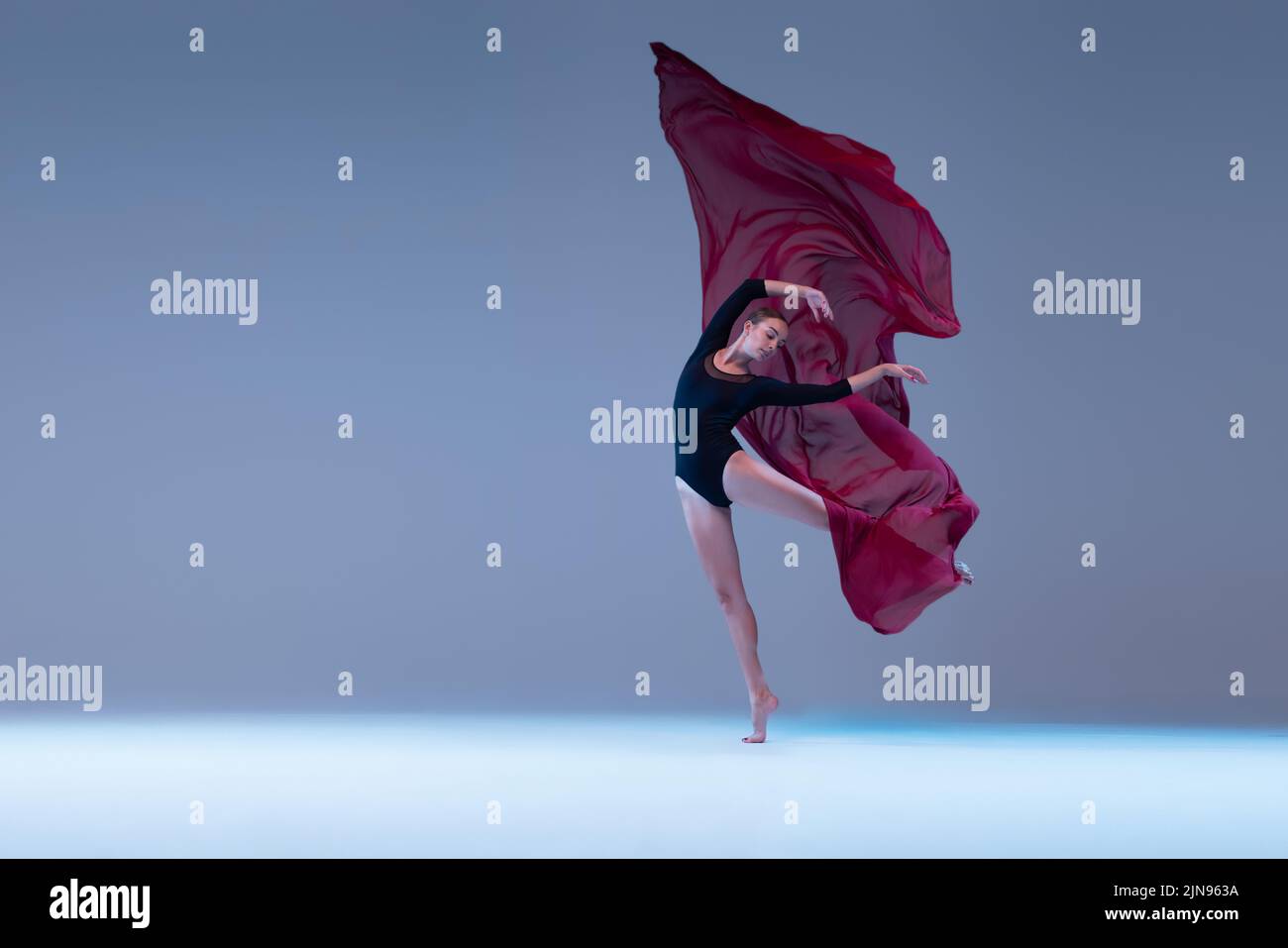 Portrait of young passionate ballerina dancing with deep red ...