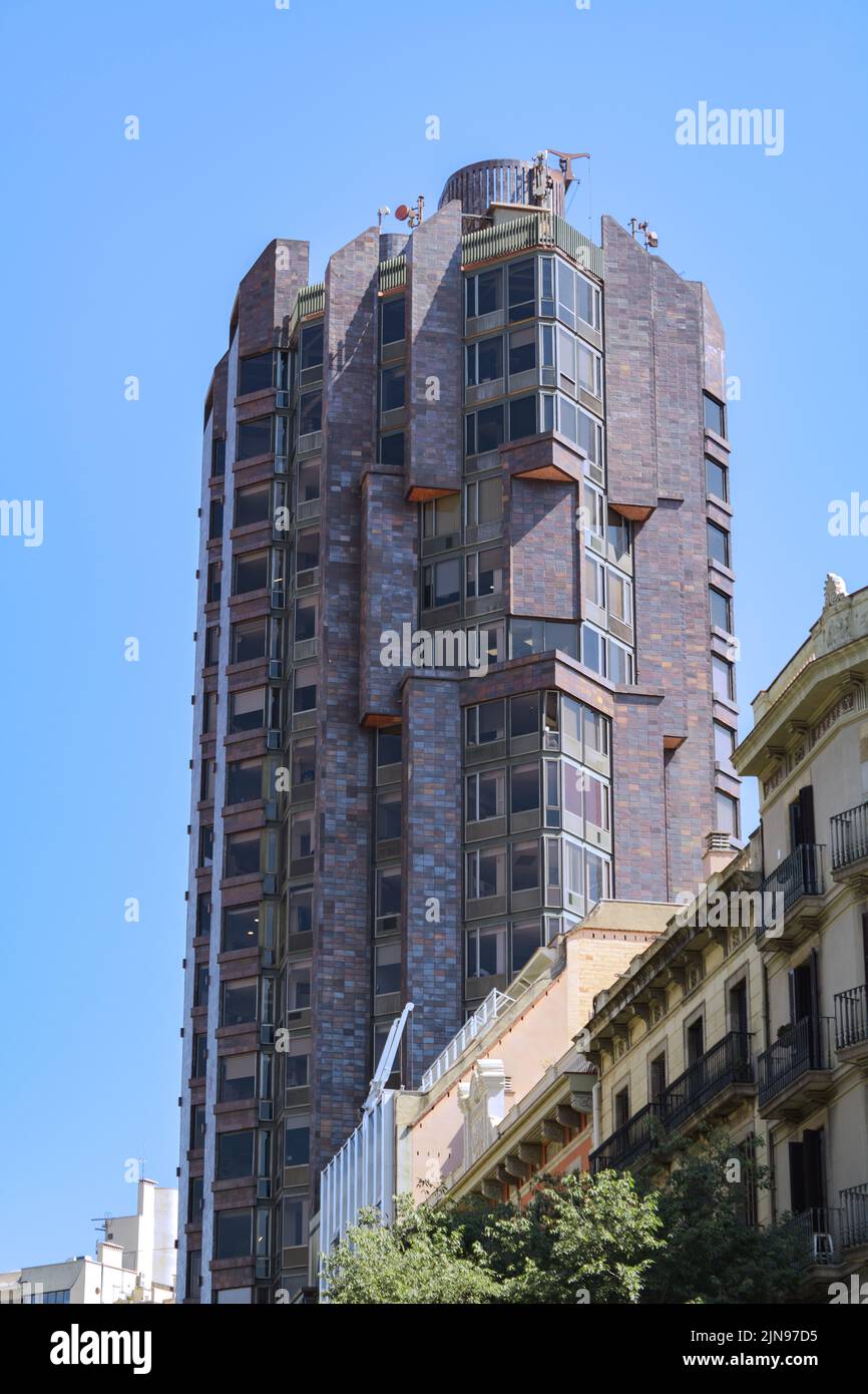 Vertical photo of a tall tower in Barcelona, Spain that contrast in the ...