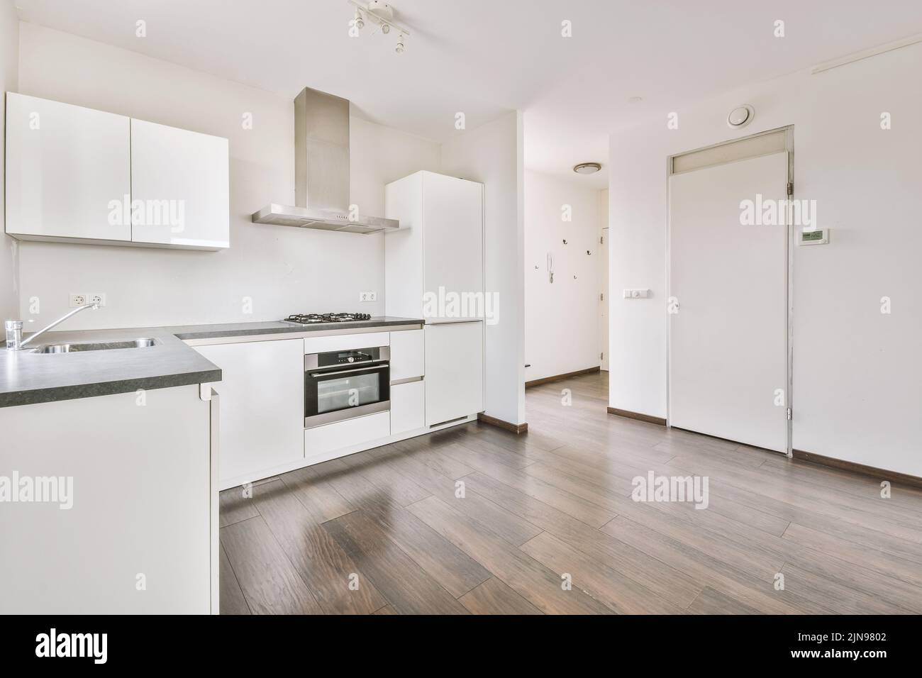 Interior of empty white kitchen with windows and wooden parquet floor ...