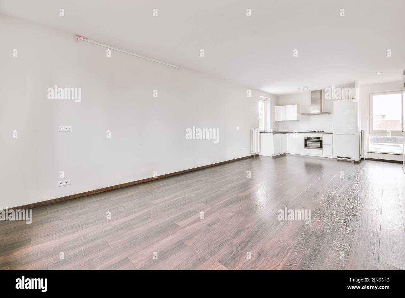 Interior of empty white kitchen with windows and wooden parquet floor ...