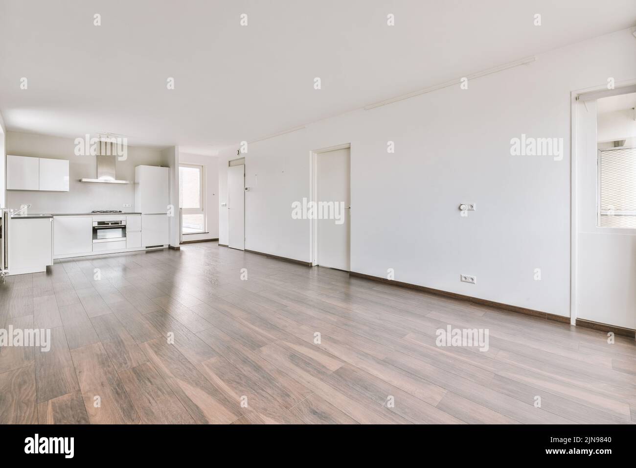 Interior of empty white kitchen with windows and wooden parquet floor ...