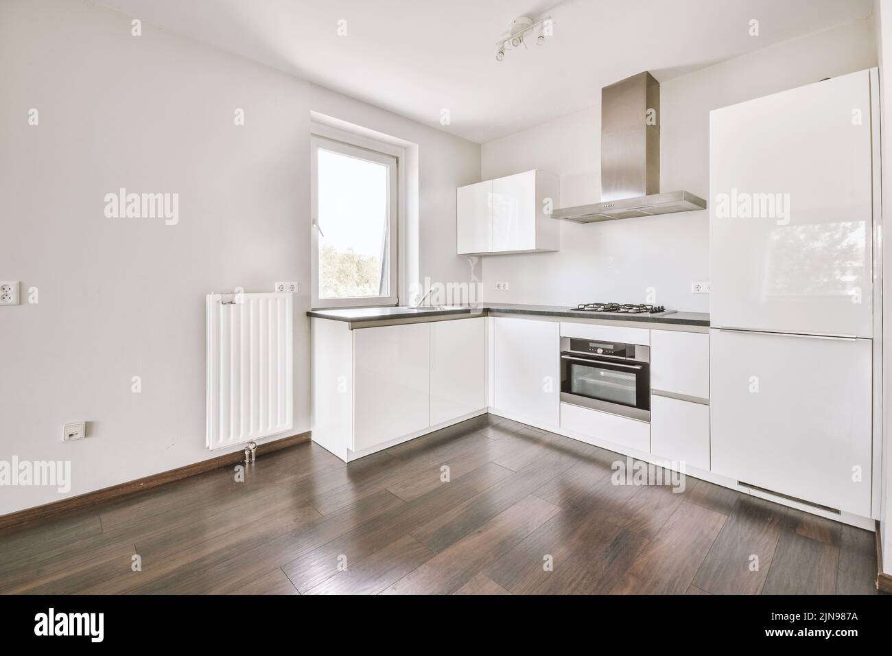 Interior of empty white kitchen with windows and wooden parquet floor ...