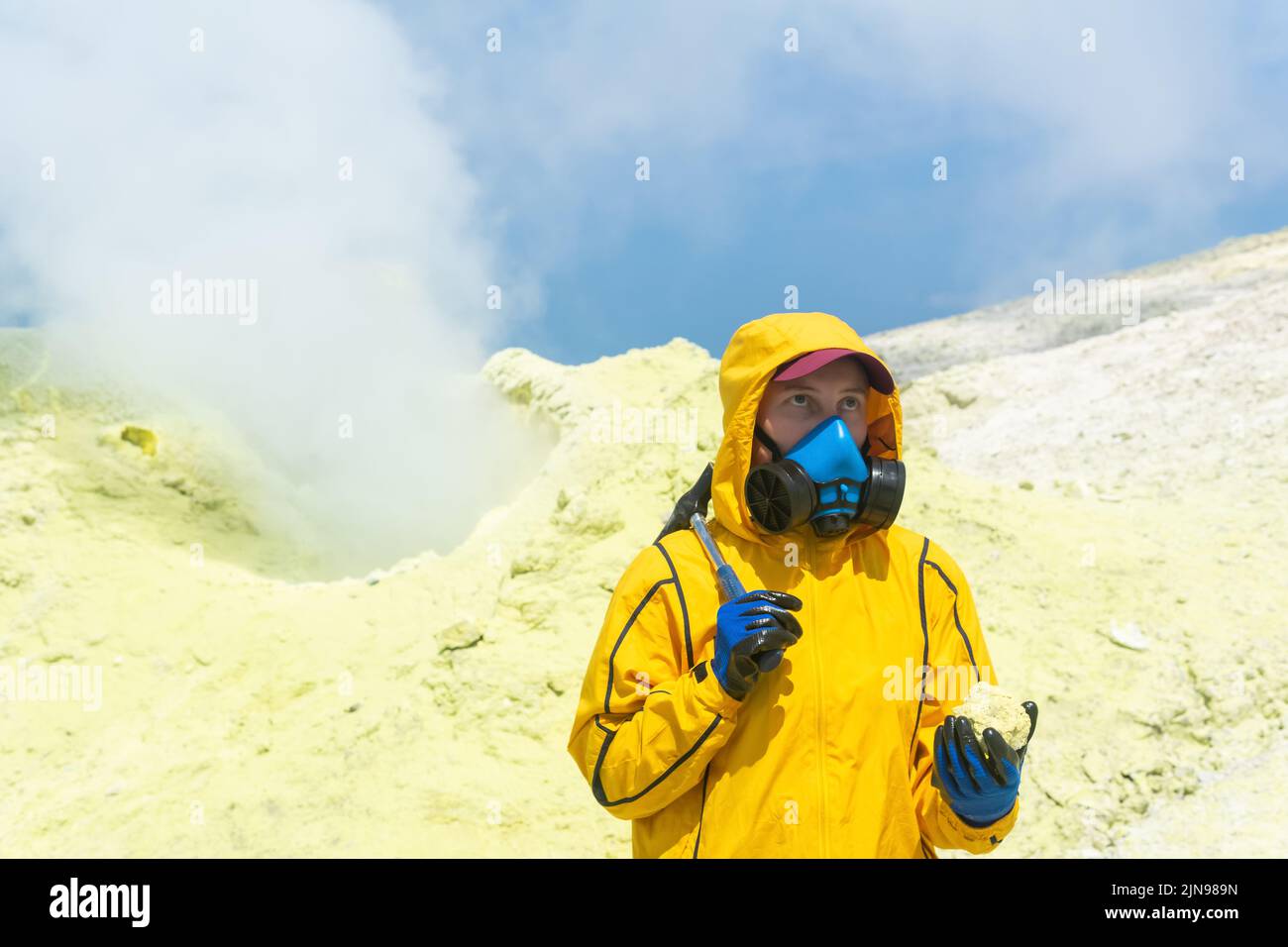 female volcano scientist with a geological hammer and a sample of a ...