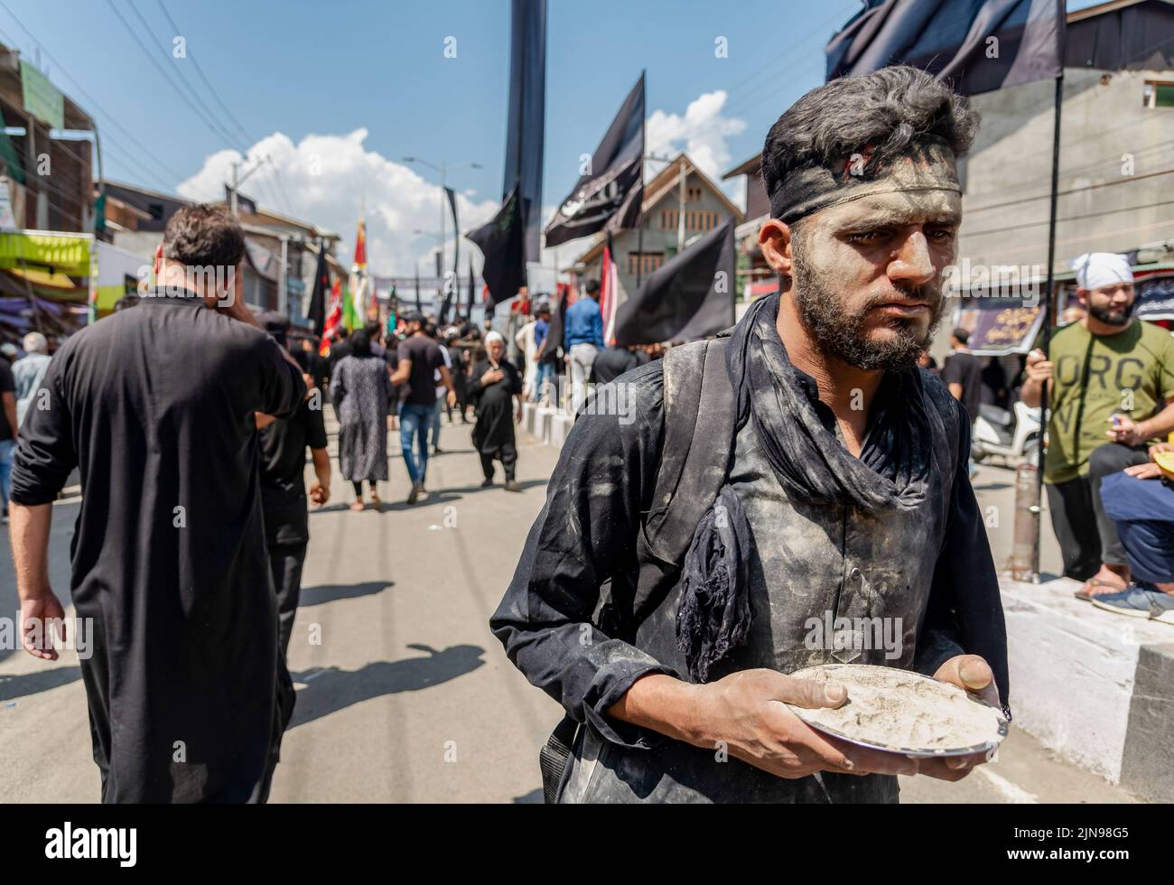 A Shia Muslim man smeared with mud taken from the soil of the holy ...
