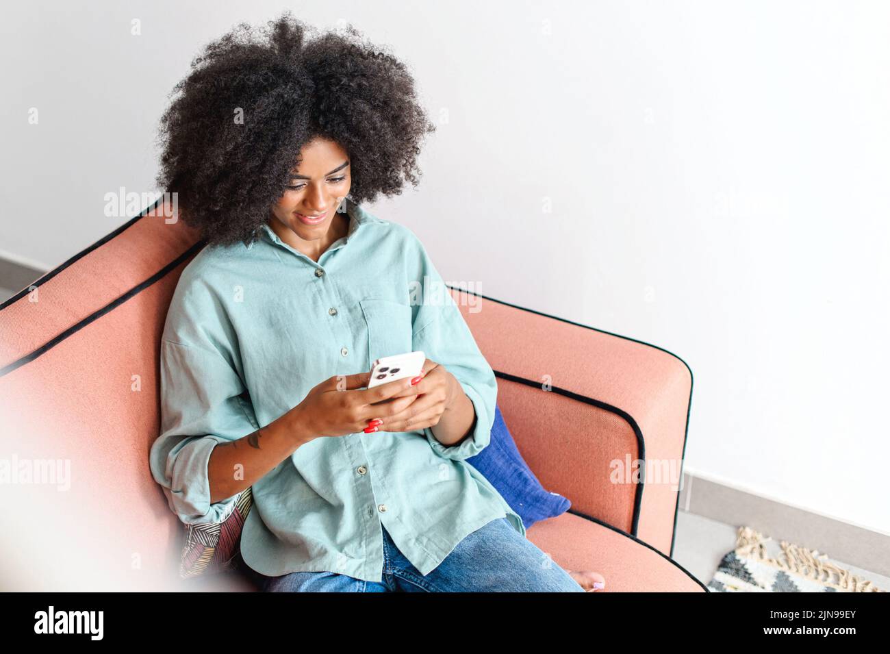 Calm and carefree african lady sitting in a relaxed pose on the ...