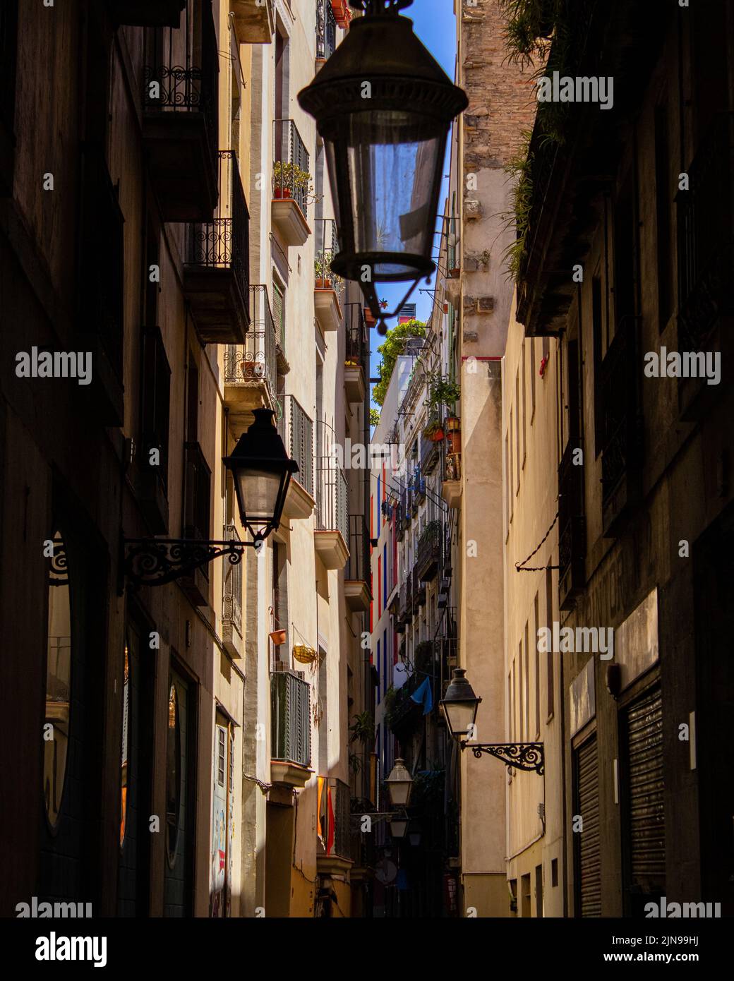 Vertical photo of a very narrow street of the gothic area in Barcelona ...