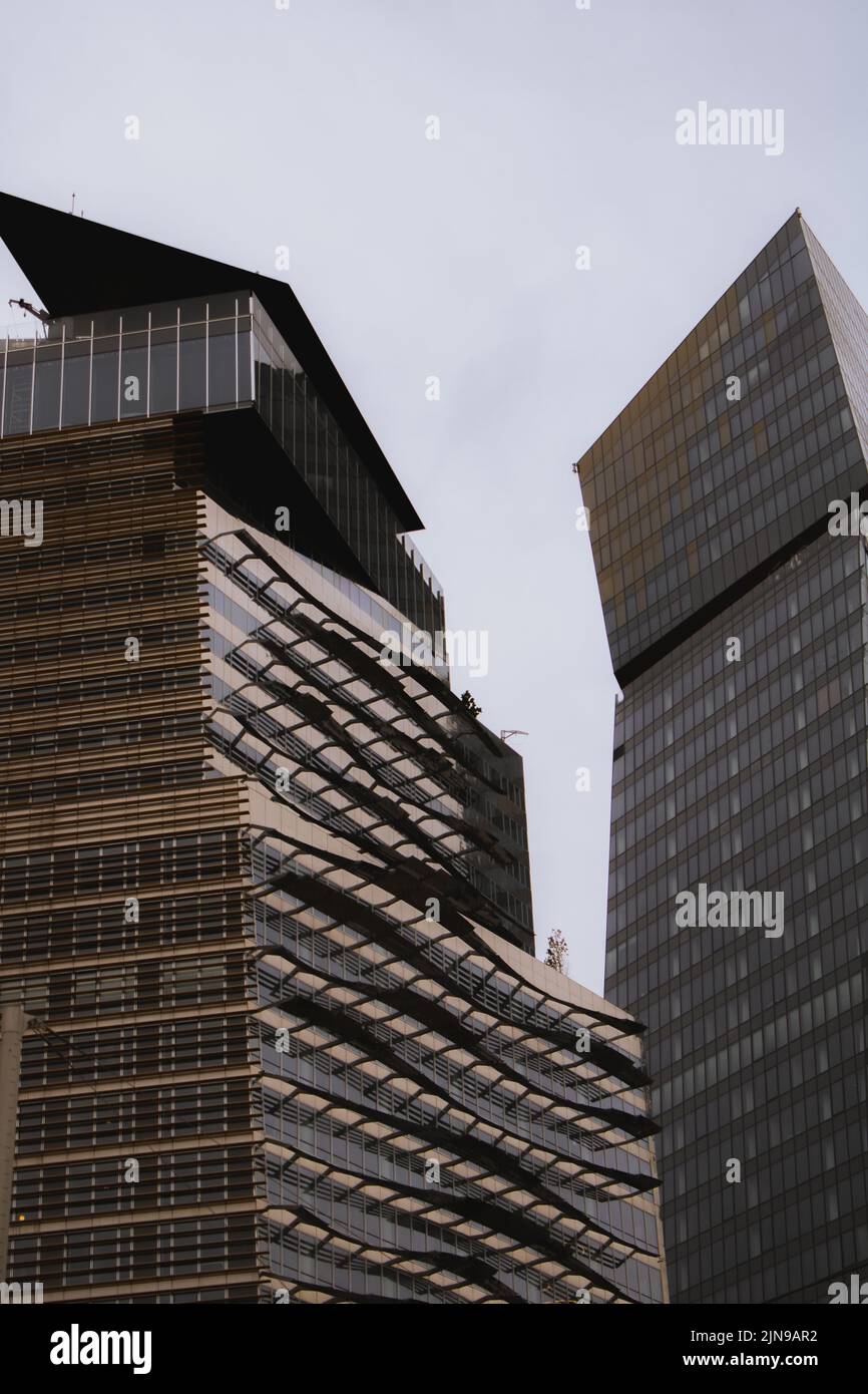 Vertical photo of two modern and glass buildings facing each other in ...