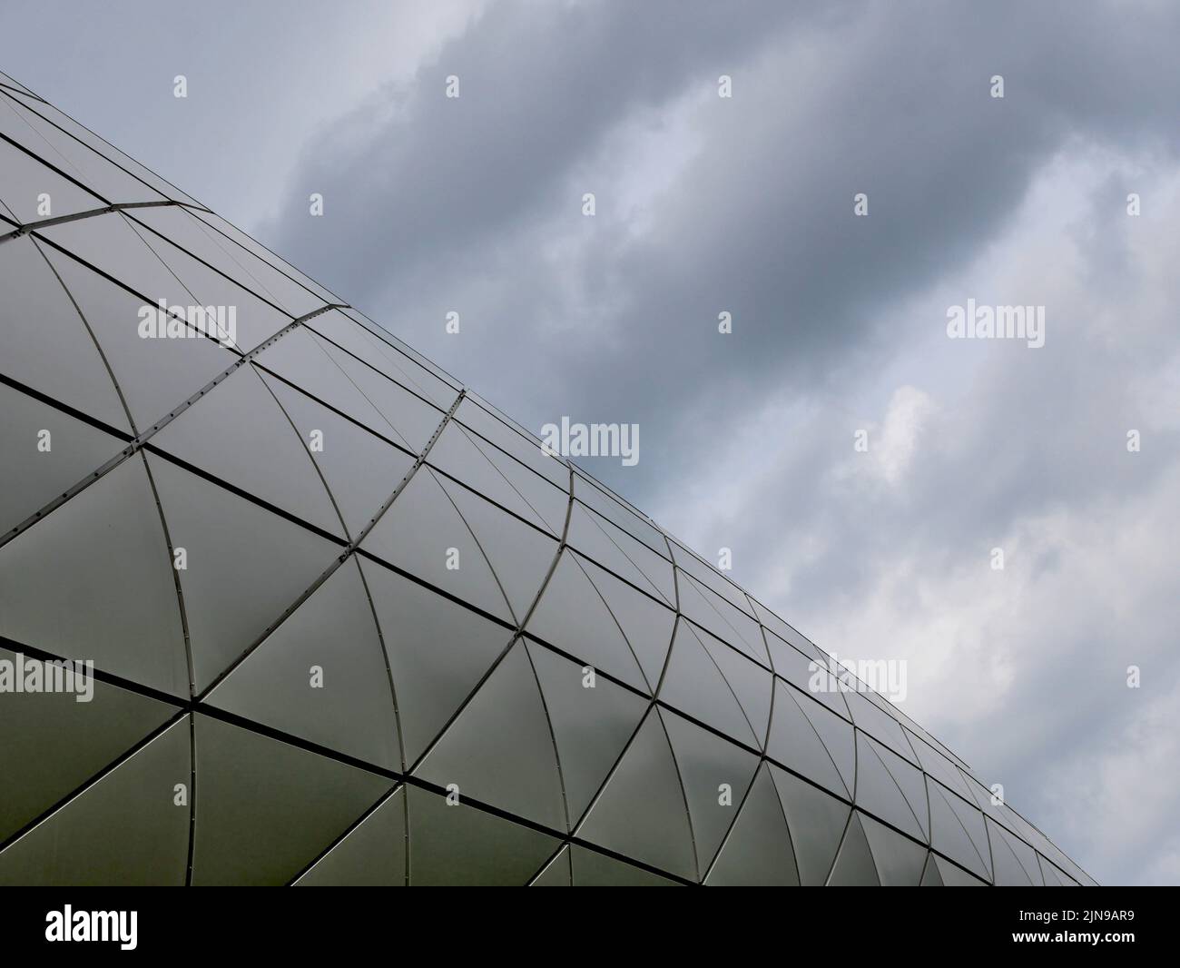 modern architecture gray triangular facade with dramatic clouds Stock ...