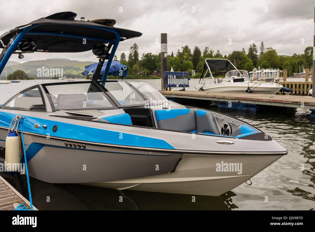 blue and white modern cutter moored at a marina during a cloudy grey ...