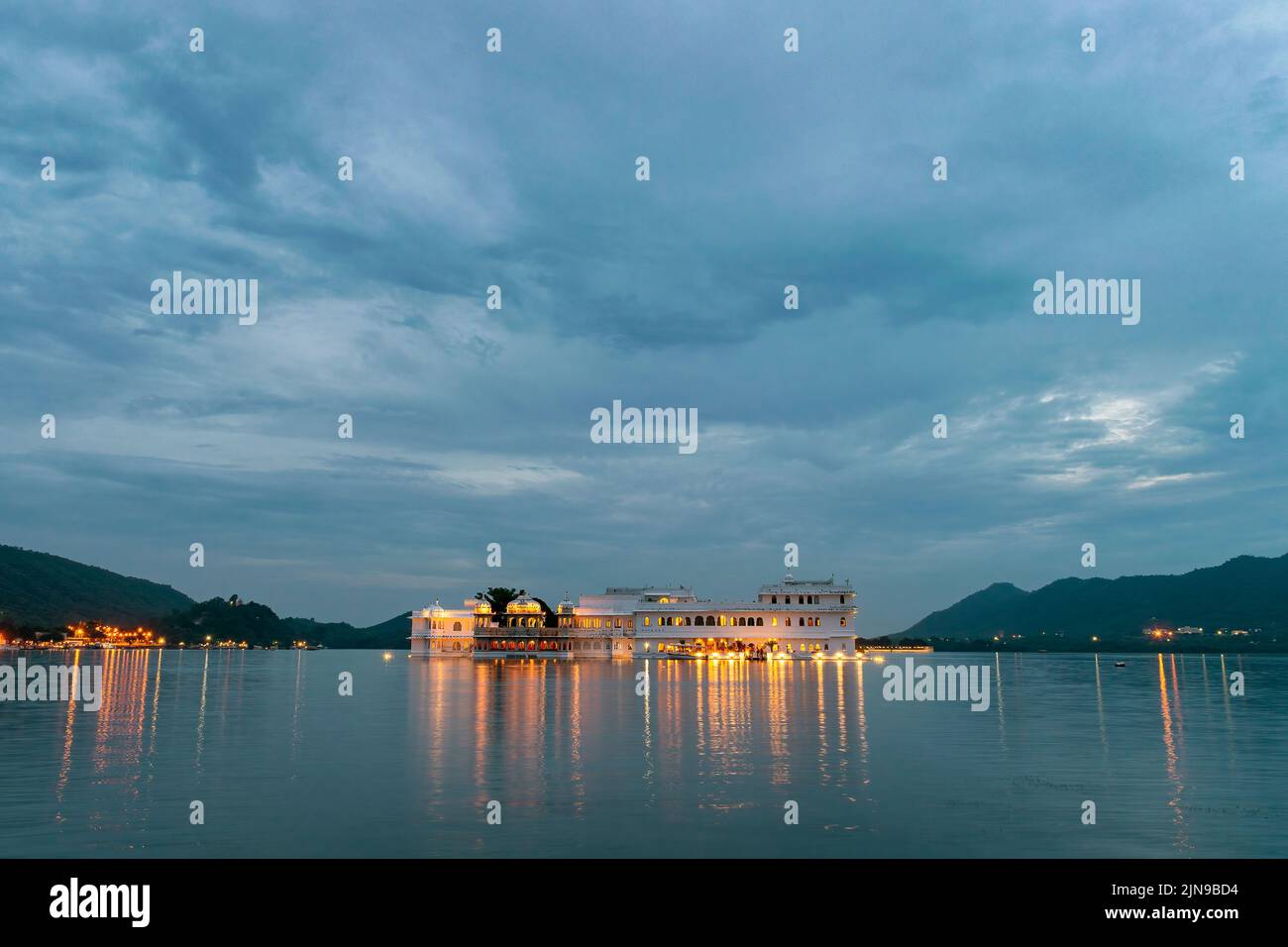 Beautiful evening view of Taj Lake Palace in Udaipur, India with lights ...