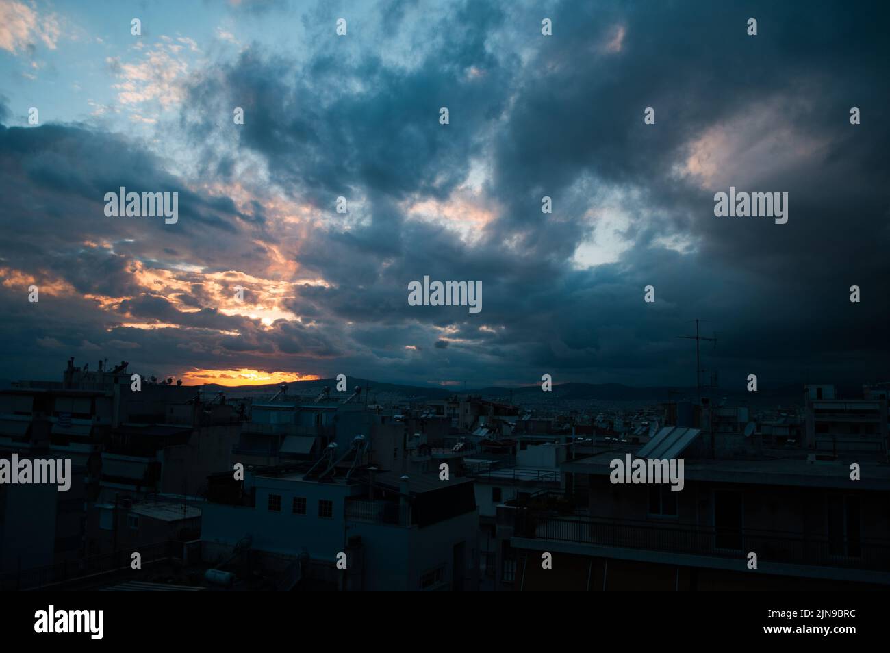 A sunset over a residential area with solar power systems on the roofs ...