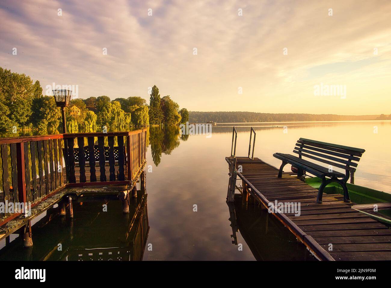 An aerial view of beach with wooden bridge and bench during sunset ...