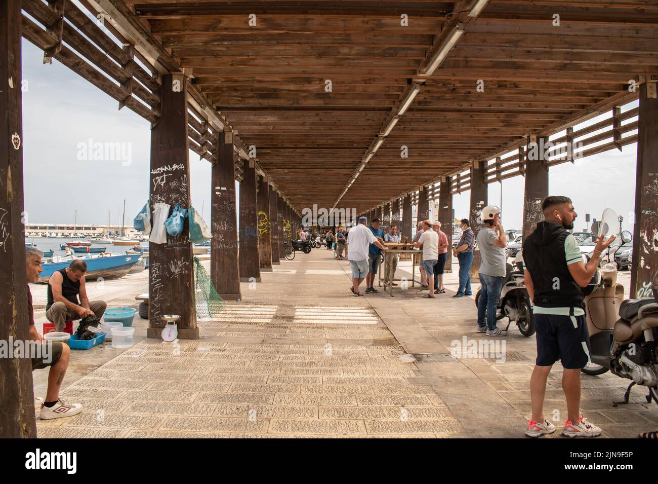 Bari harbour pier with locals and fish sellers Stock Photo - Alamy