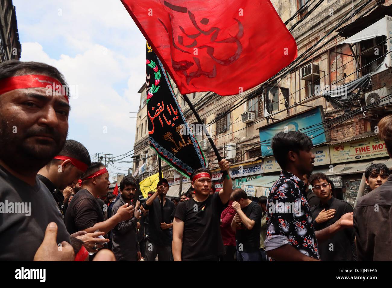 Shi'ite Muslim men wave flags at a congregation to mark Ashura, the ...