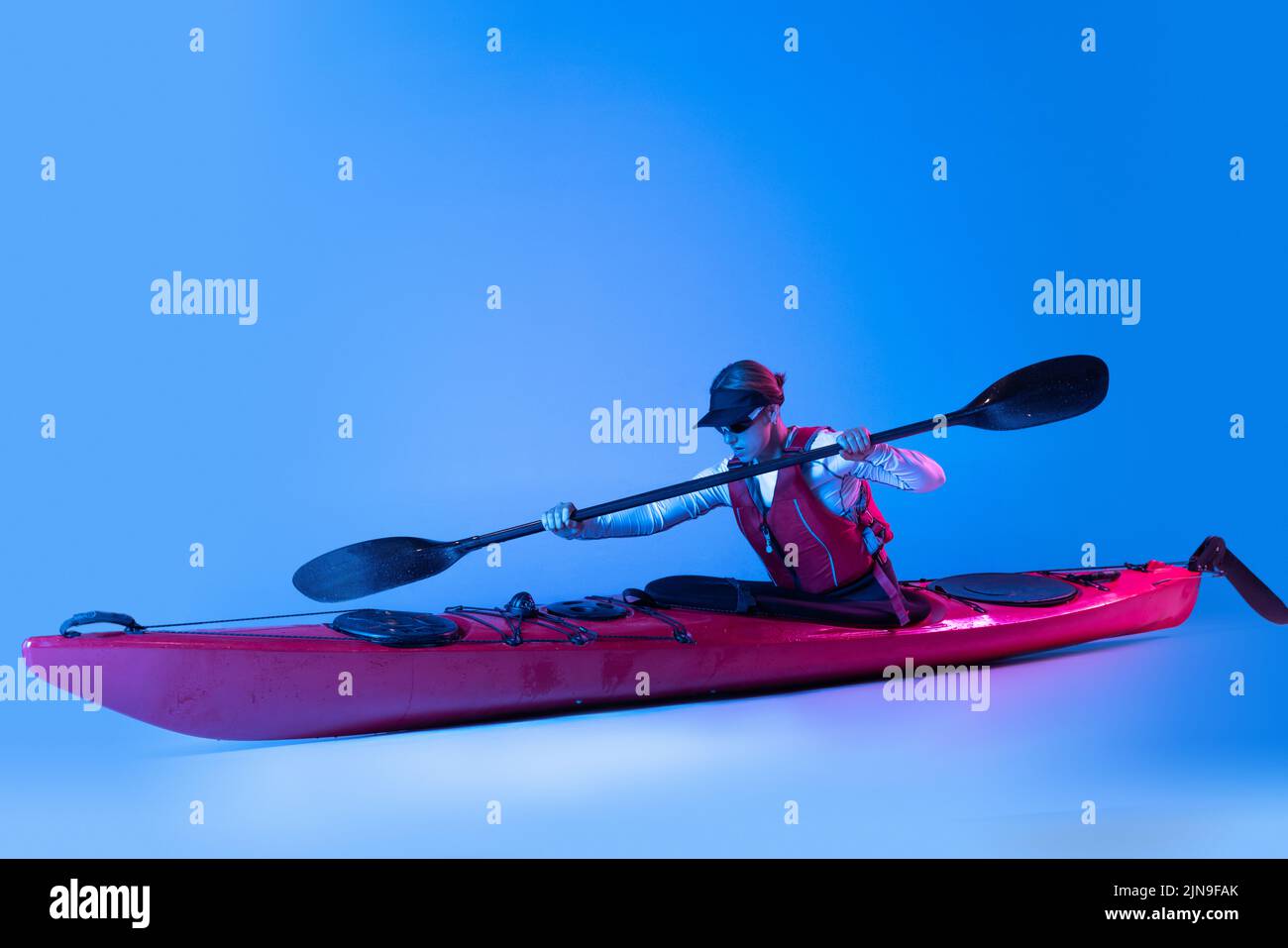 Canoeing. Sportive woman in red canoe, kayak with a life vest and a ...
