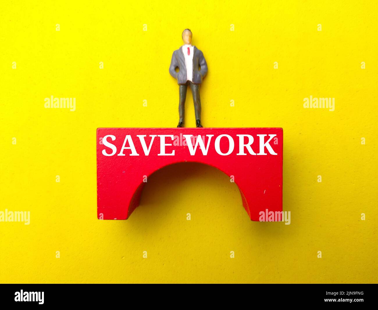 A miniature man and colored block with the word SAVE WORK Stock Photo ...