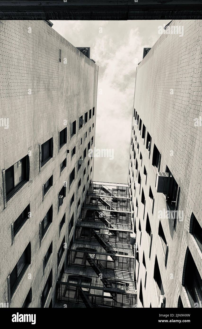 A vertical low angle greyscale of a building with stairs outside Stock Photo - Alamy