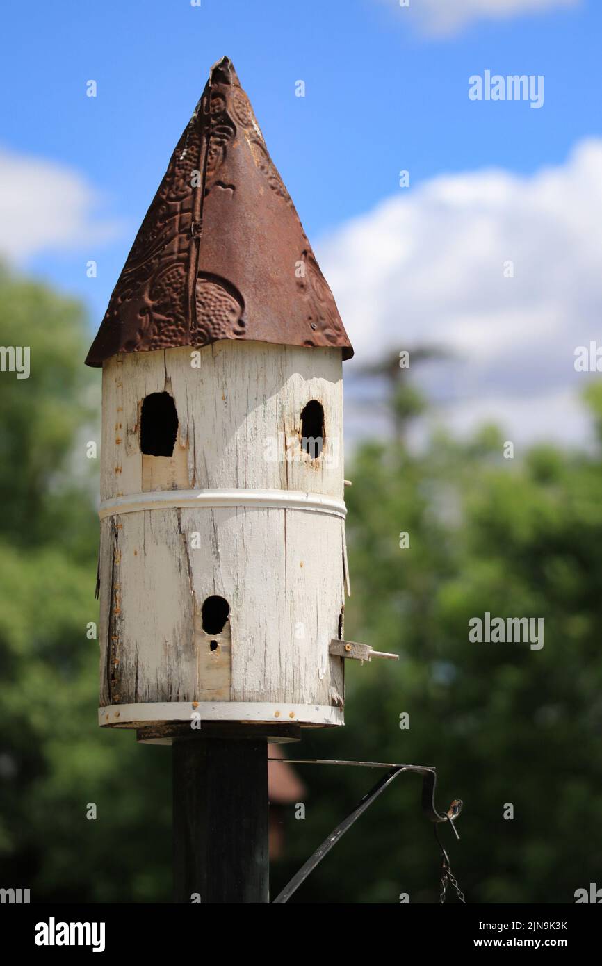 Wooden cylindrical birdhouse with metal roof cap Stock Photo - Alamy