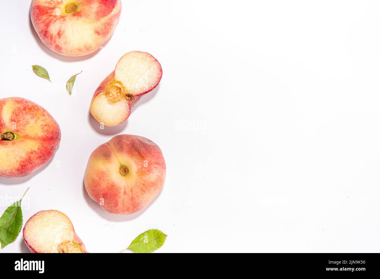 Ripe organic chinese flat fig peach, whole and slices, with leaves ...