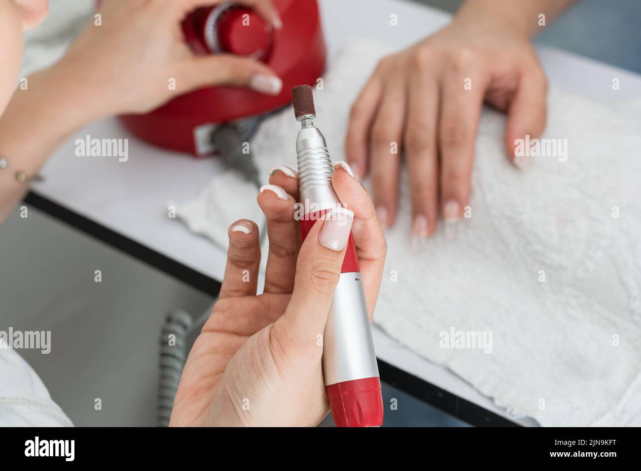 detail of the manicurist's hand holding the electric nail buffer ideal ...