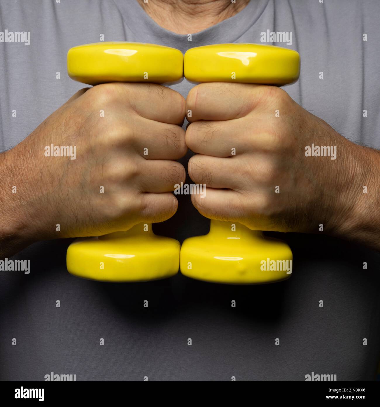 yellow gymnastic weights in hand Stock Photo - Alamy