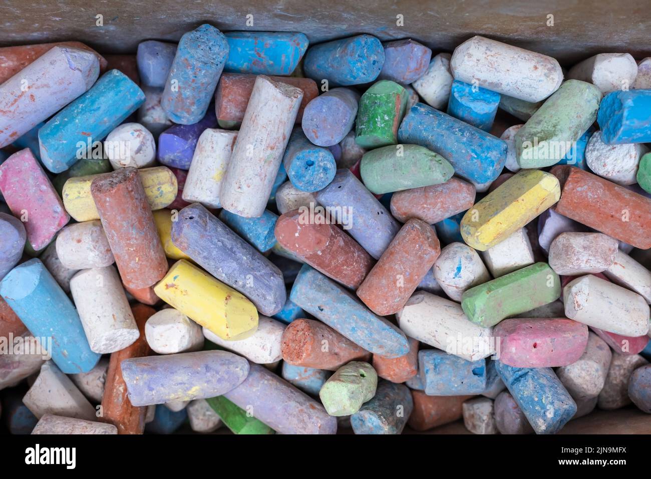 Pile of colored crayons. Multi-colored bright pieces of chalk. Top view ...