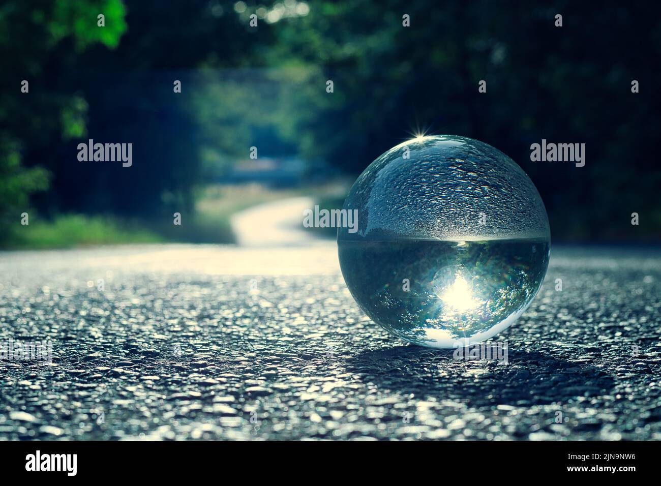 A glass sphere with water on the ground Stock Photo - Alamy