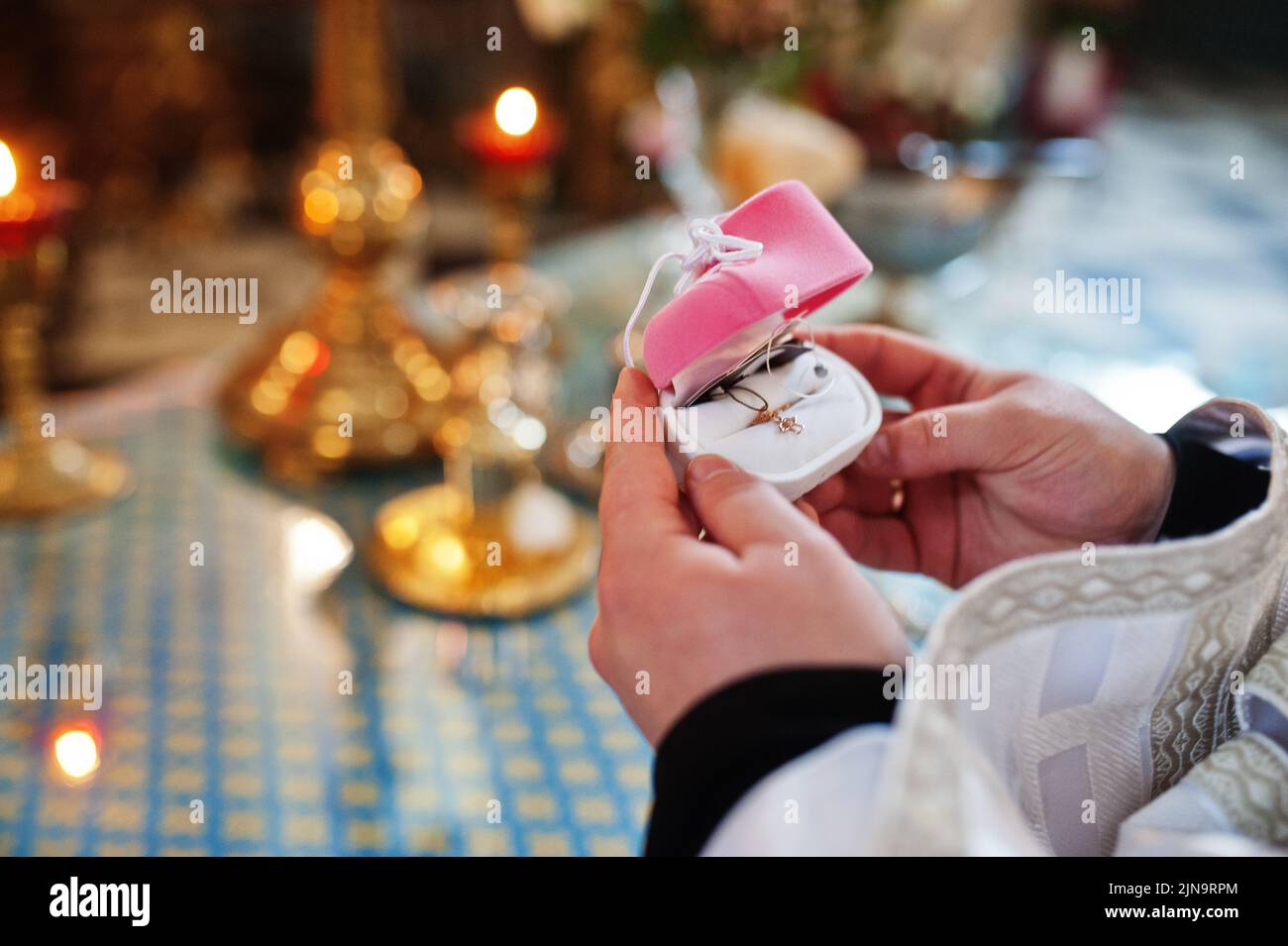 Hand of priest at rite of baptism hold pendant with an angel Stock ...