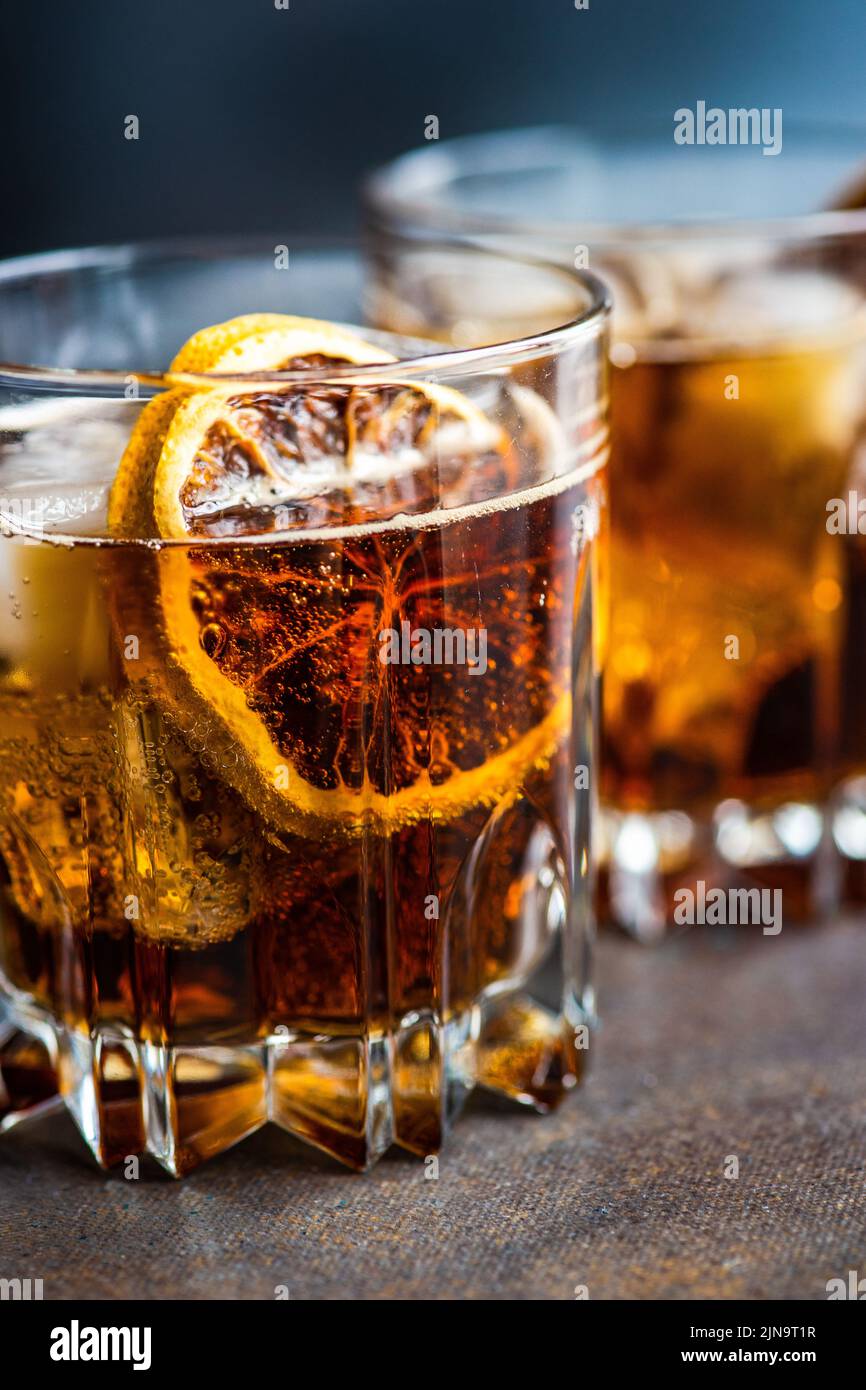 Alcohol cocktail with coke in the glass with slice of orange and ice ...
