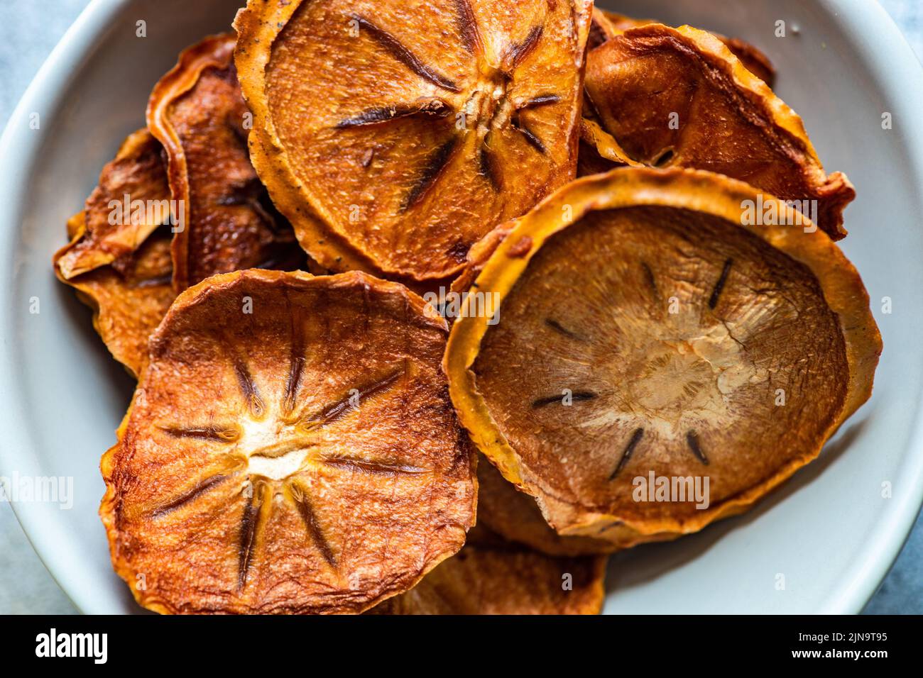 Sweet and healthy snack with persimmon chips in the bowl Stock Photo ...