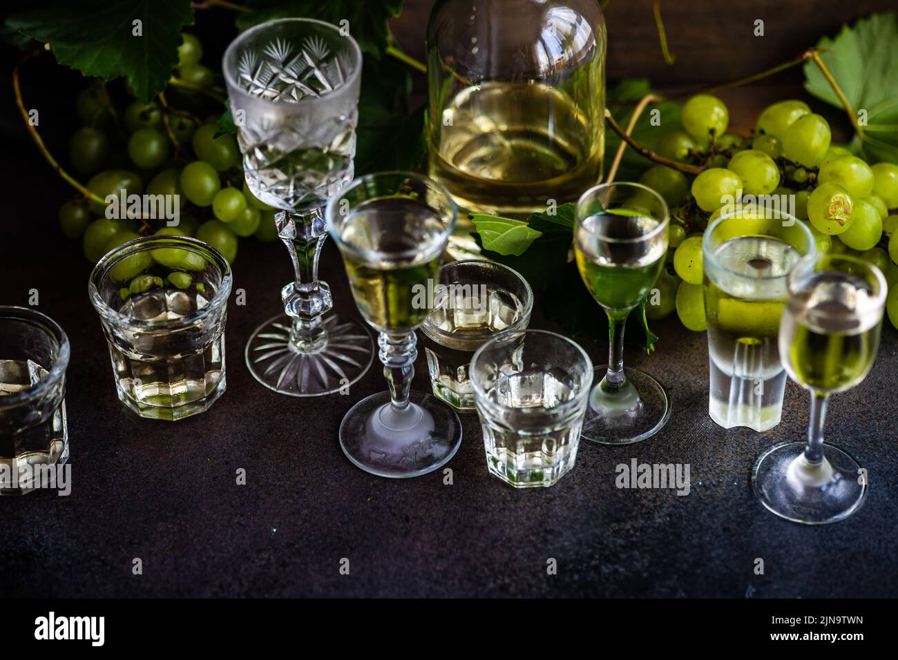 Georgian grape chacha drink in the bottle and glasses on dark rustic ...