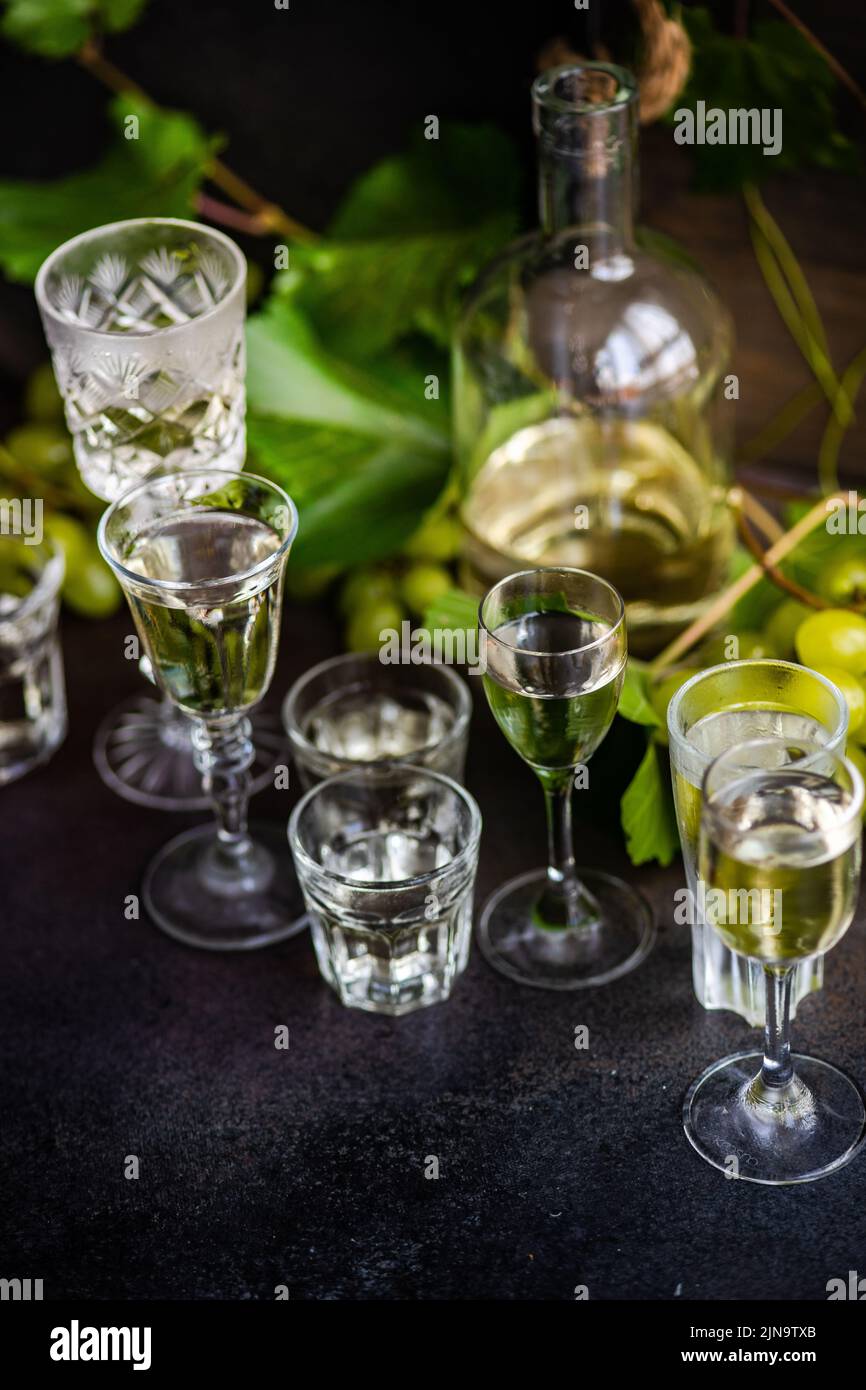 Georgian grape chacha drink in the bottle and glasses on dark rustic ...