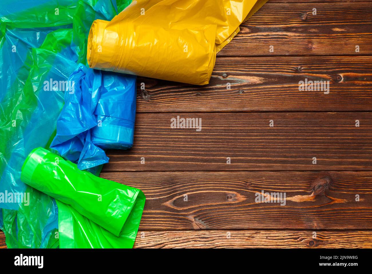 Different plastic bags on wooden background Stock Photo - Alamy
