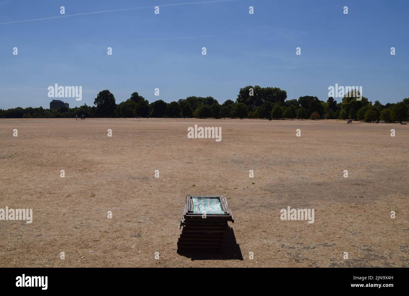 London, UK. 10th August 2022. Folded deckchairs in a parched Hyde Park ...