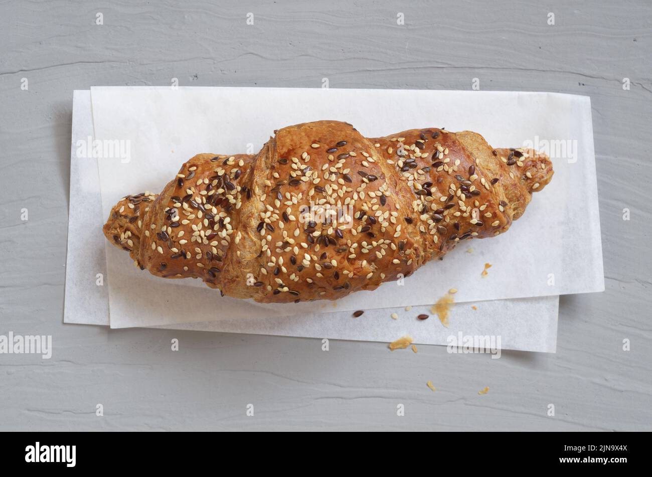 Top view of croissant with seeds of flax on gray stone background Stock ...