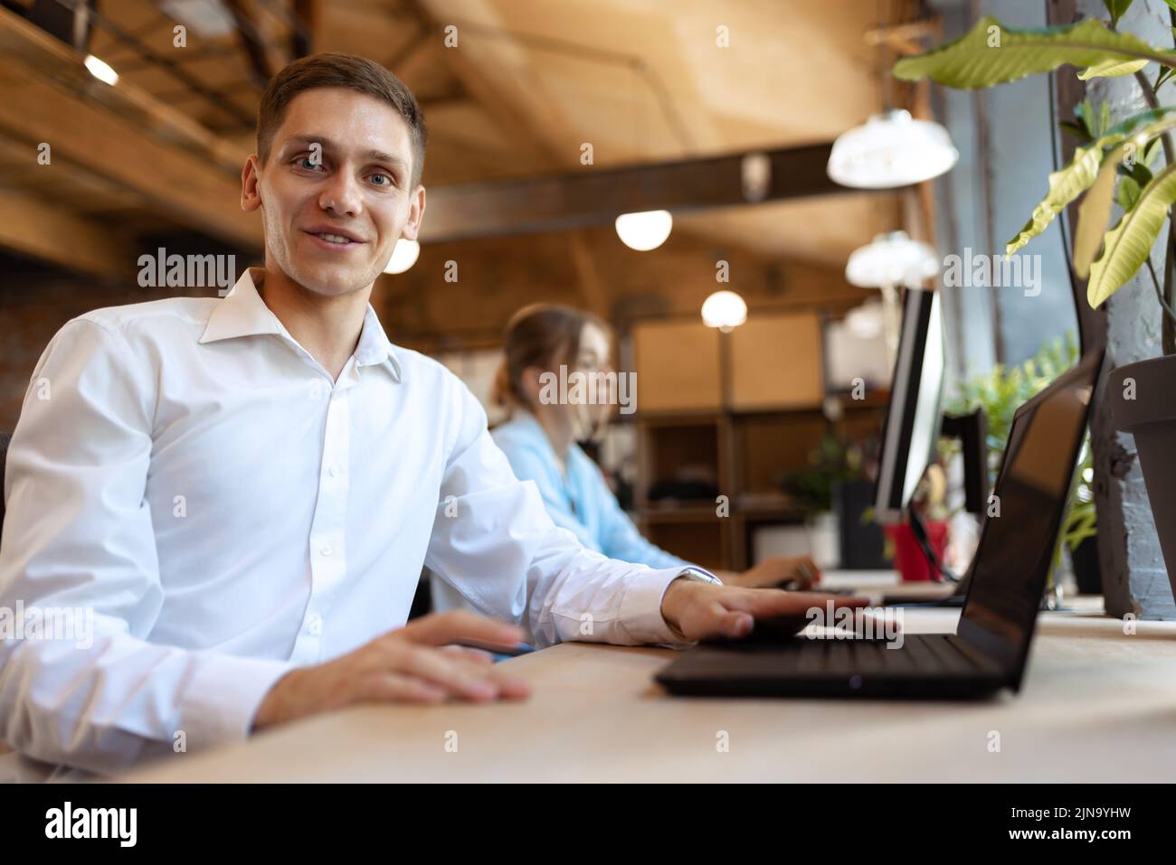 Senior developer. Happy man looking at camera and smilling. Work in modern loft style office ...