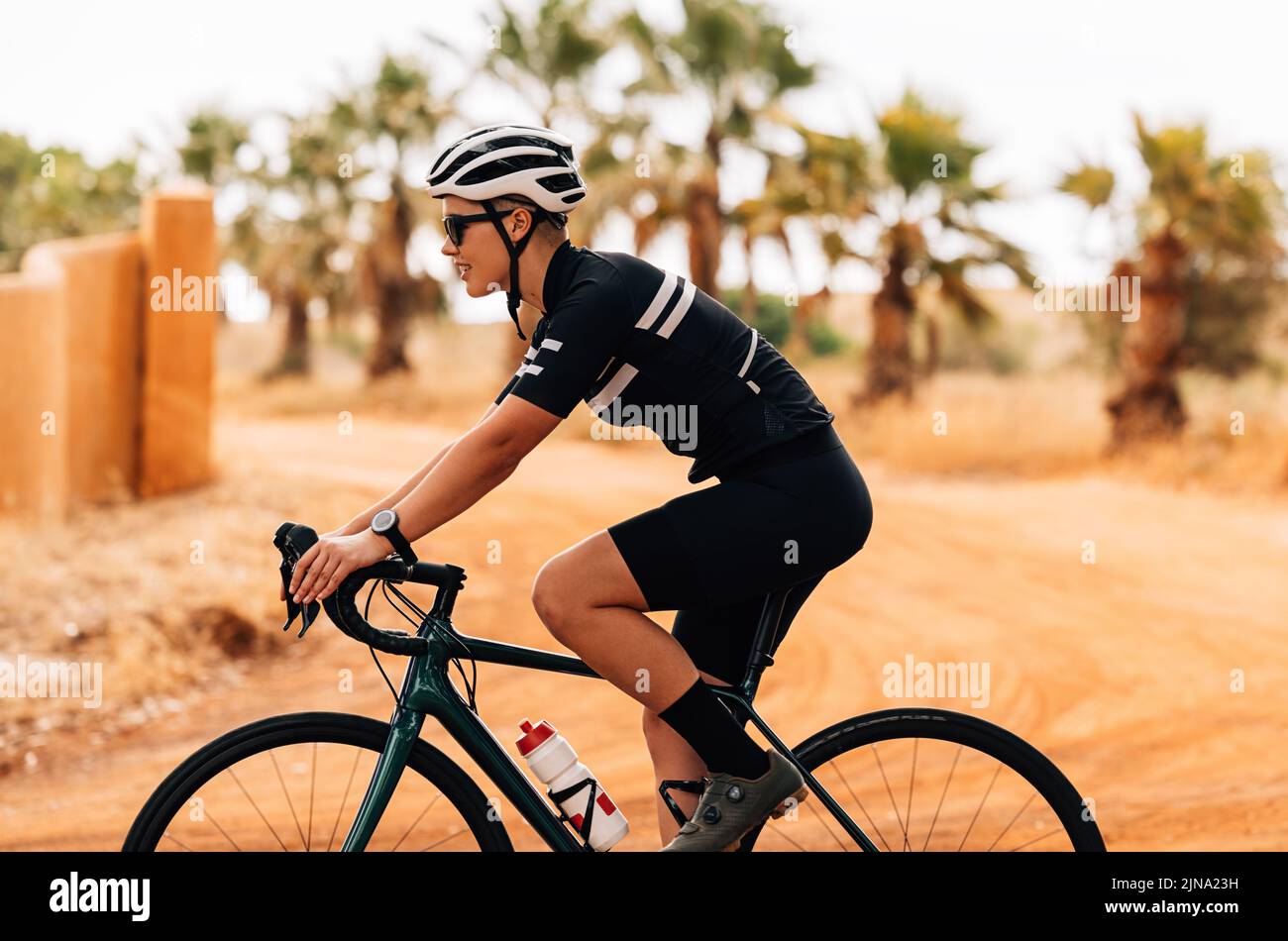 Side view of professional female cyclist riding her bike Stock Photo ...