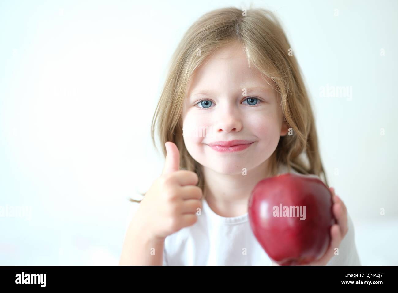 Little beautiful beautiful chooses red tasty juicy apple Stock Photo ...